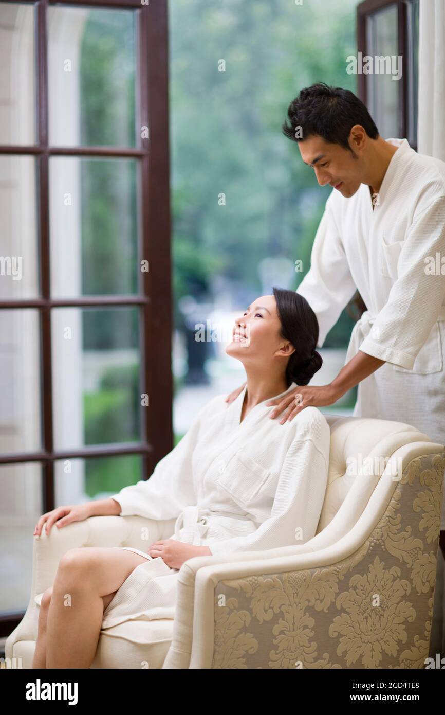 Young man giving young woman a shoulder massage Stock Photo - Alamy