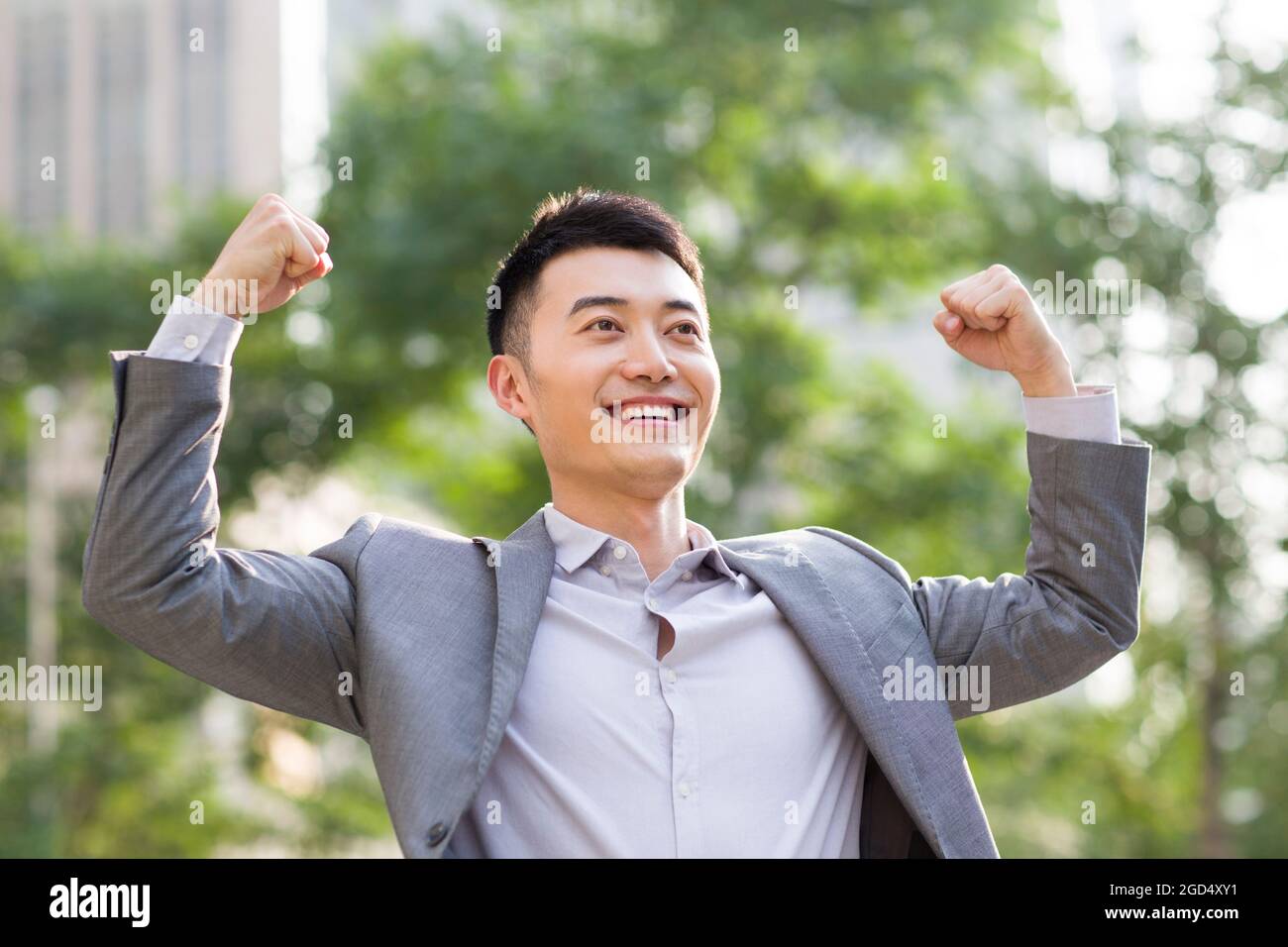 Cheerful businessman flexing his muscles Stock Photo - Alamy