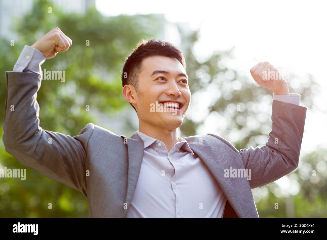 Cheerful businessman flexing his muscles Stock Photo - Alamy