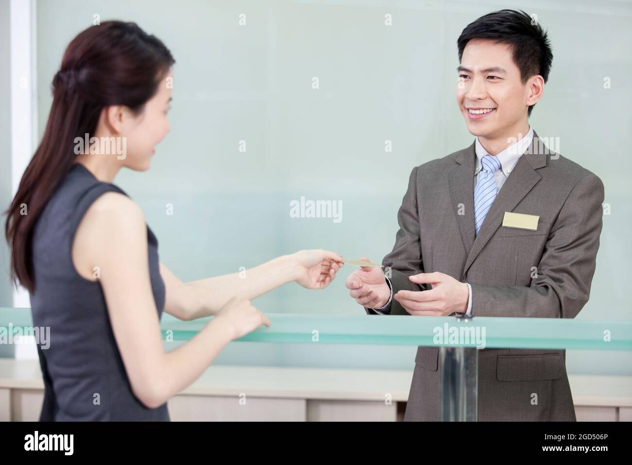 Businesswoman check in at reception desk Stock Photo - Alamy