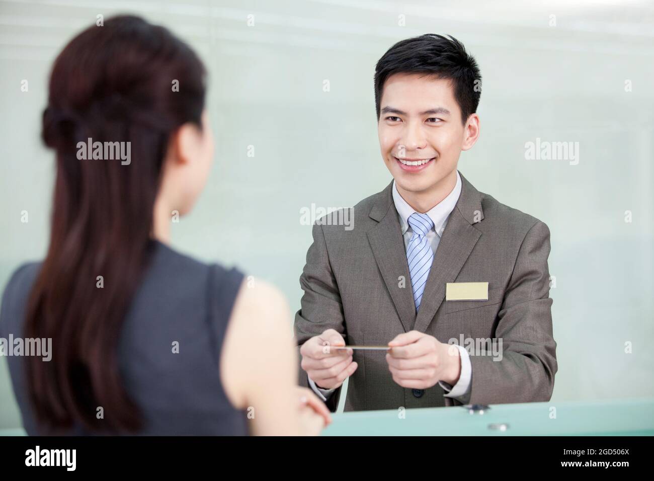 Businesswoman check in at reception desk Stock Photo - Alamy
