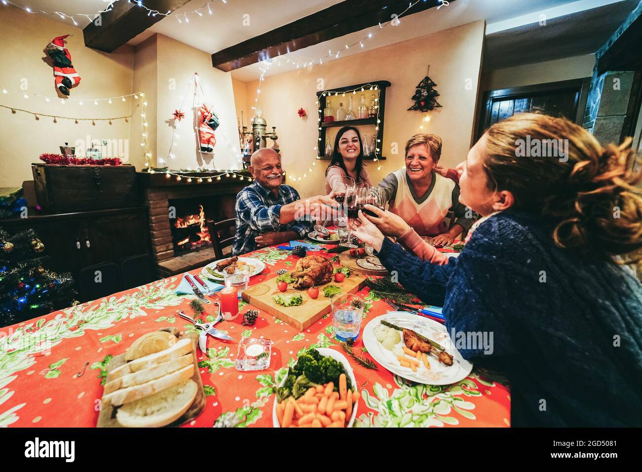 Happy family cheering with red wine while eating Christmas holiday ...