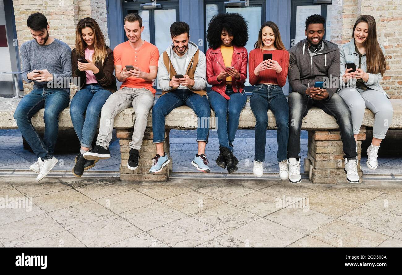 Young diverse people using mobile phones outdoor in the city - Focus on ...