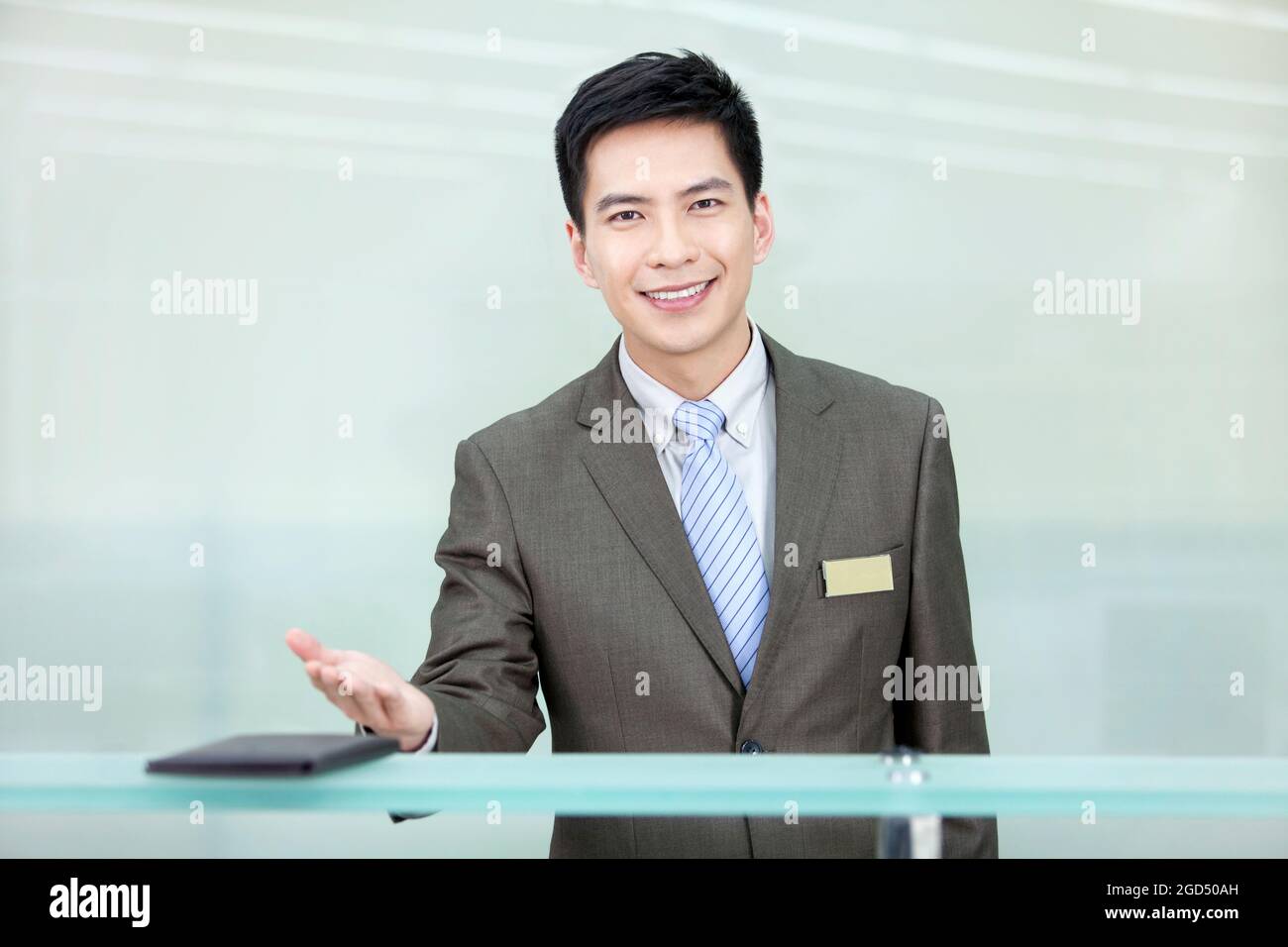 Businessman greeting at reception desk Stock Photo - Alamy