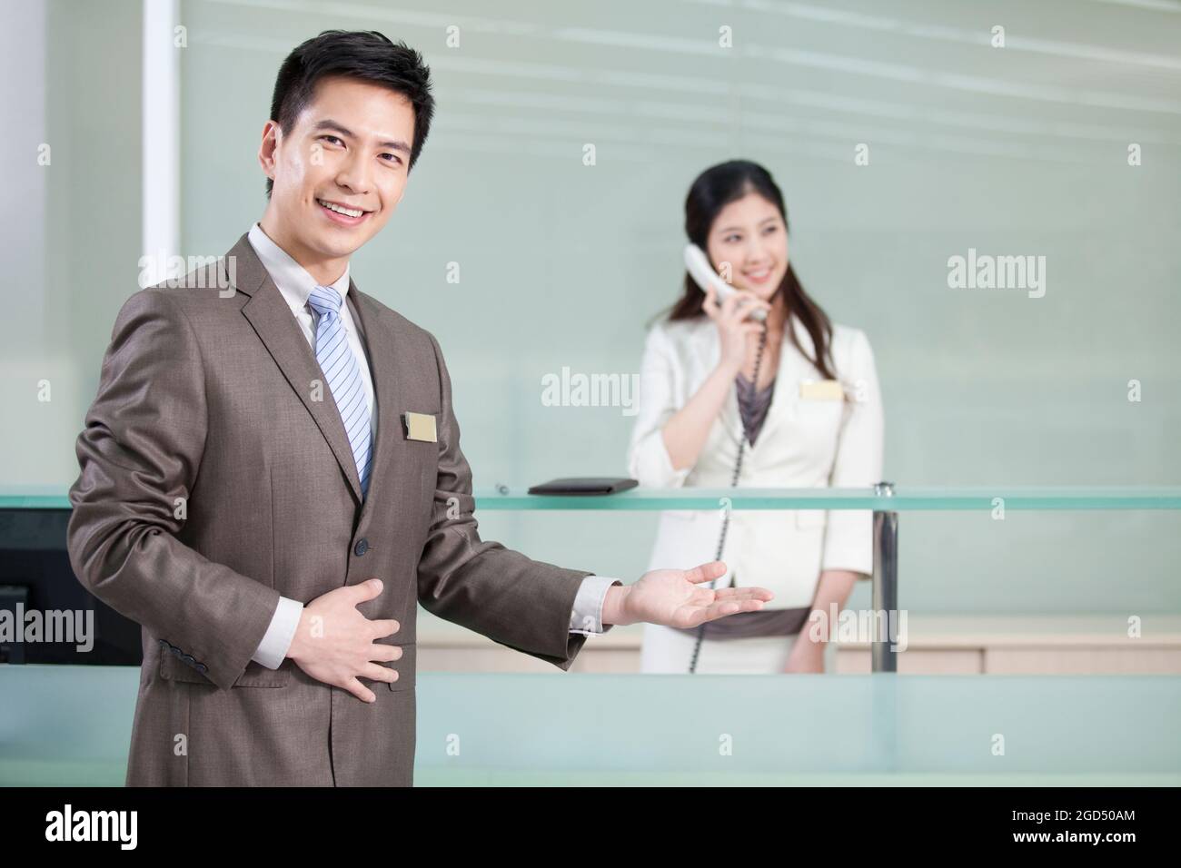 Businessman greeting at reception desk Stock Photo - Alamy