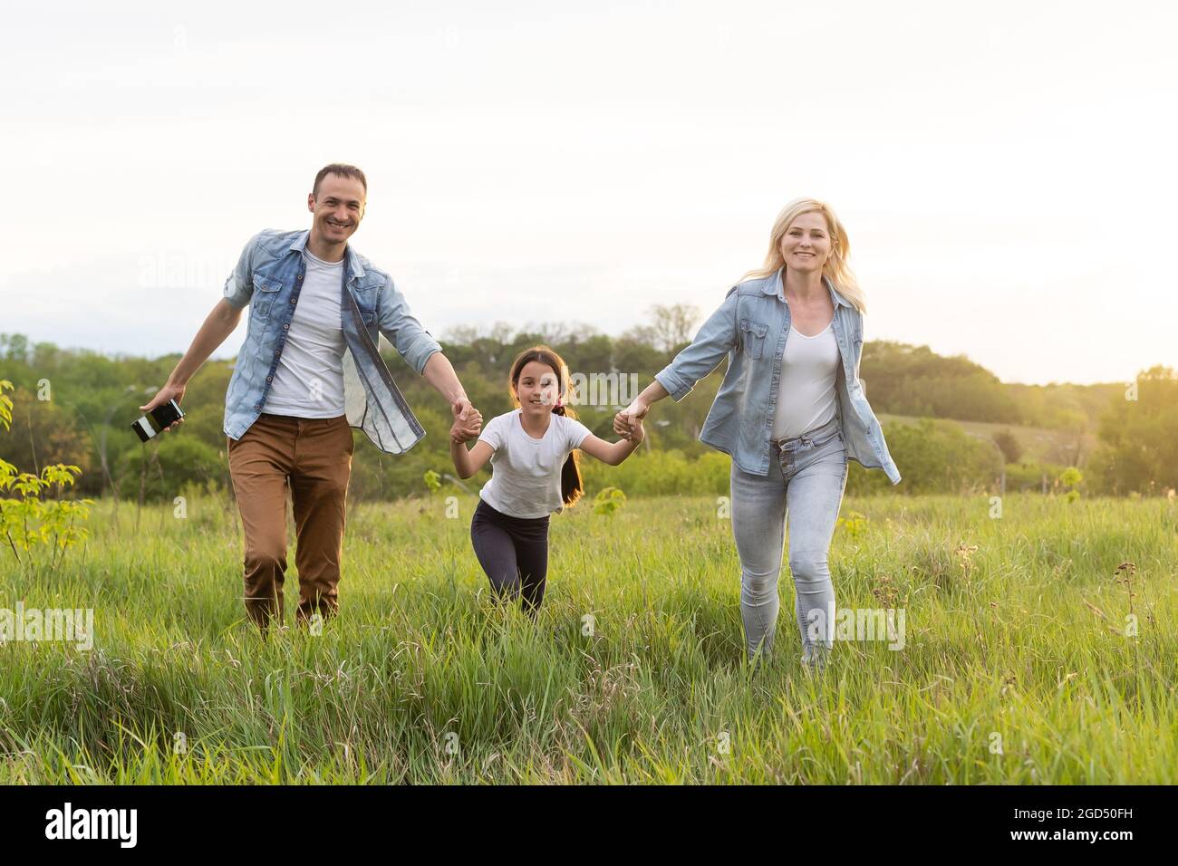 Happy family: mother father and child daughter on nature on sunset ...