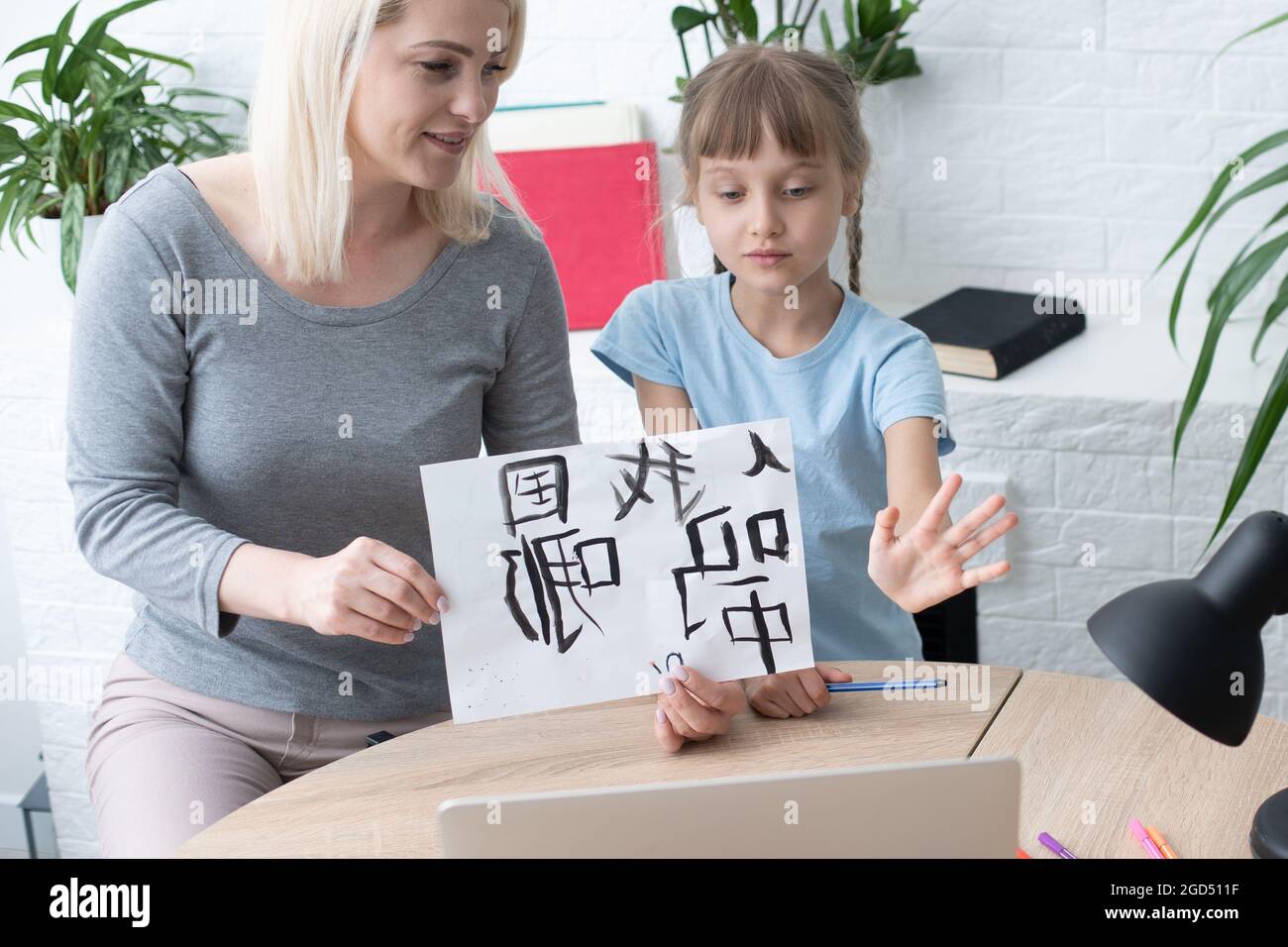 little girl learning chinese while using her laptop computer in the ...