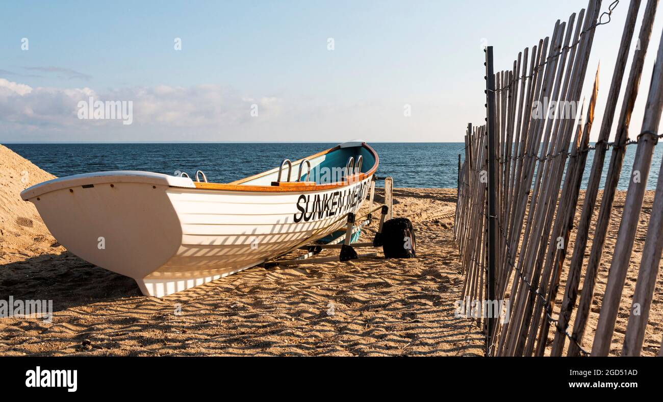 White lifeguards row boat on the sand next to a fence at Sunken Meadow ...
