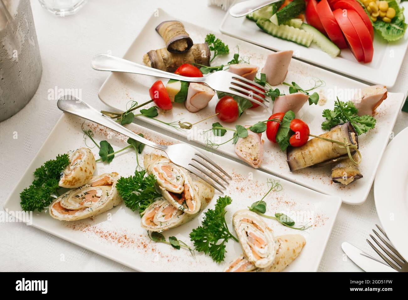Snacks on white plates on a festive banquet table at a wedding. Top ...