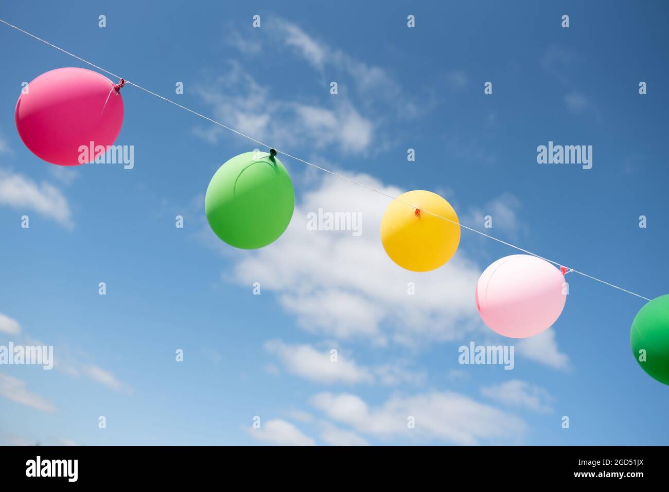 Colorful bright balloons on a string on a blue sky background Stock ...