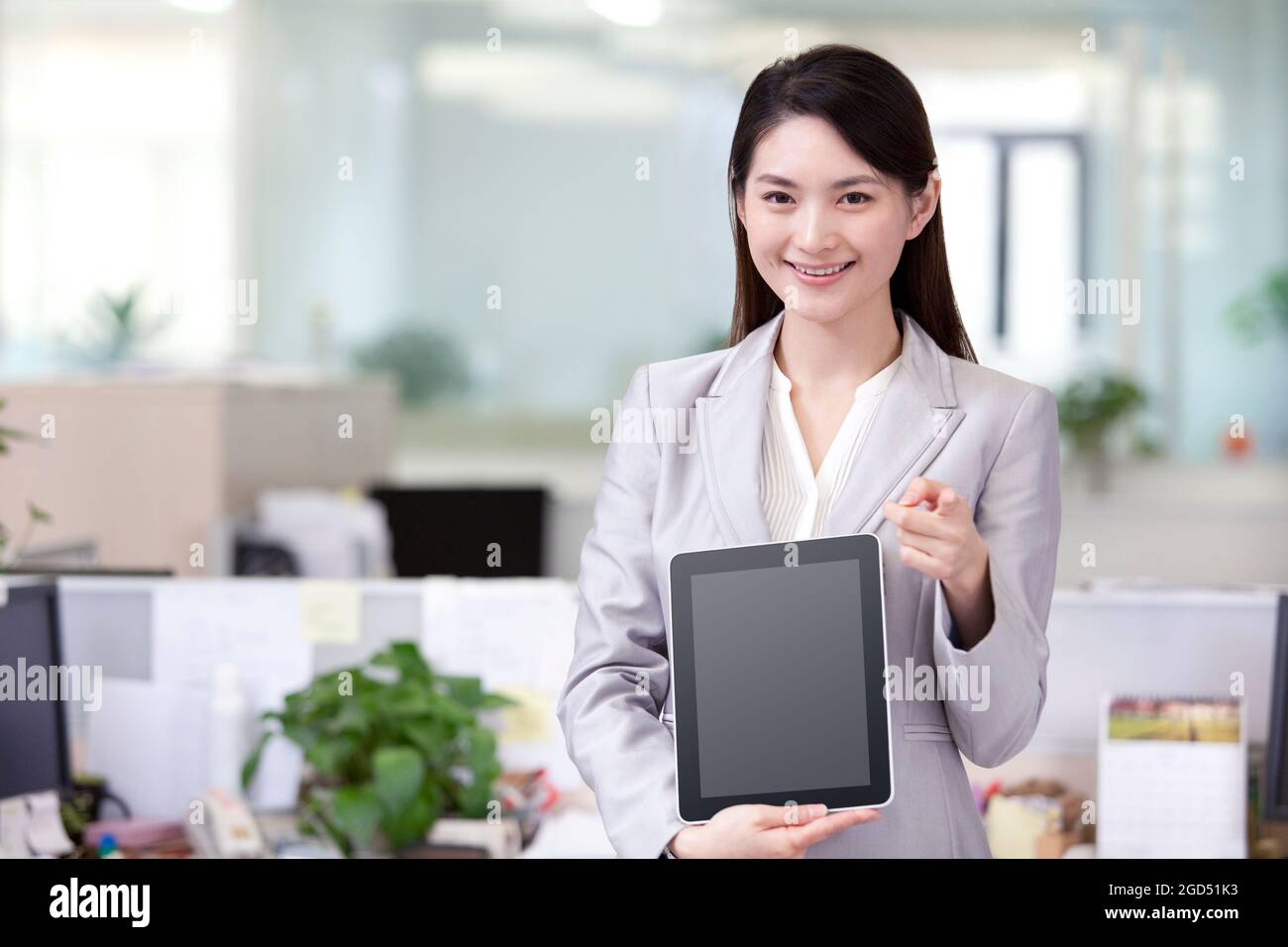Cheerful office lady showing digital tablet Stock Photo - Alamy