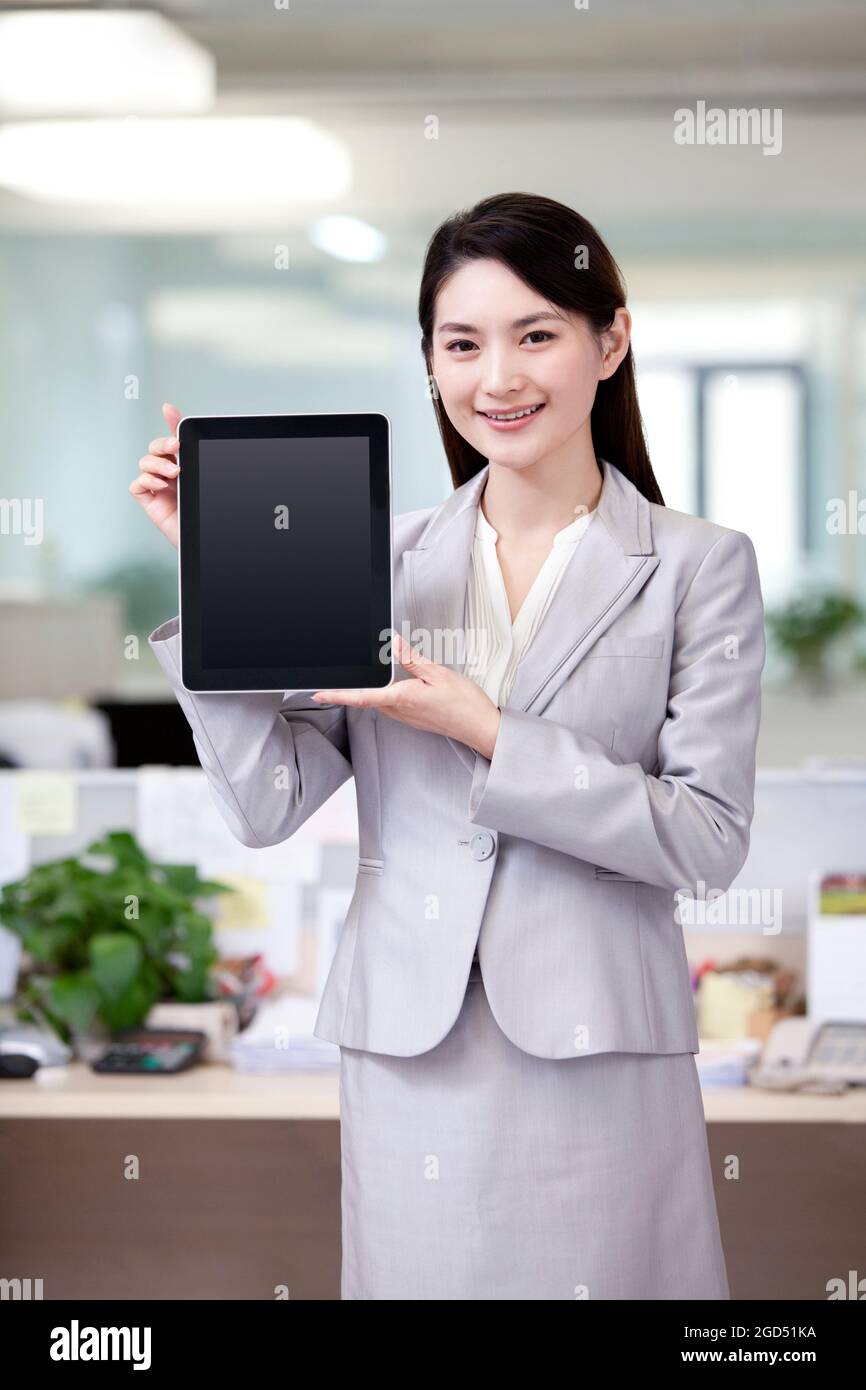 Cheerful office lady showing digital tablet Stock Photo - Alamy