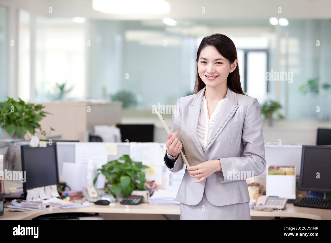 Cheerful office lady with a file in office Stock Photo - Alamy