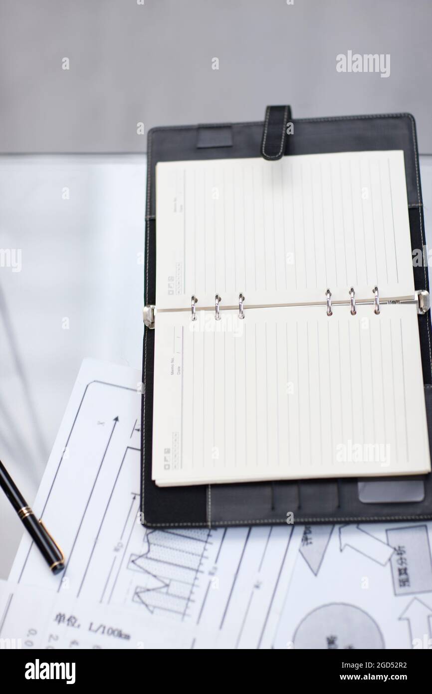 Notepad and business charts on desk Stock Photo - Alamy