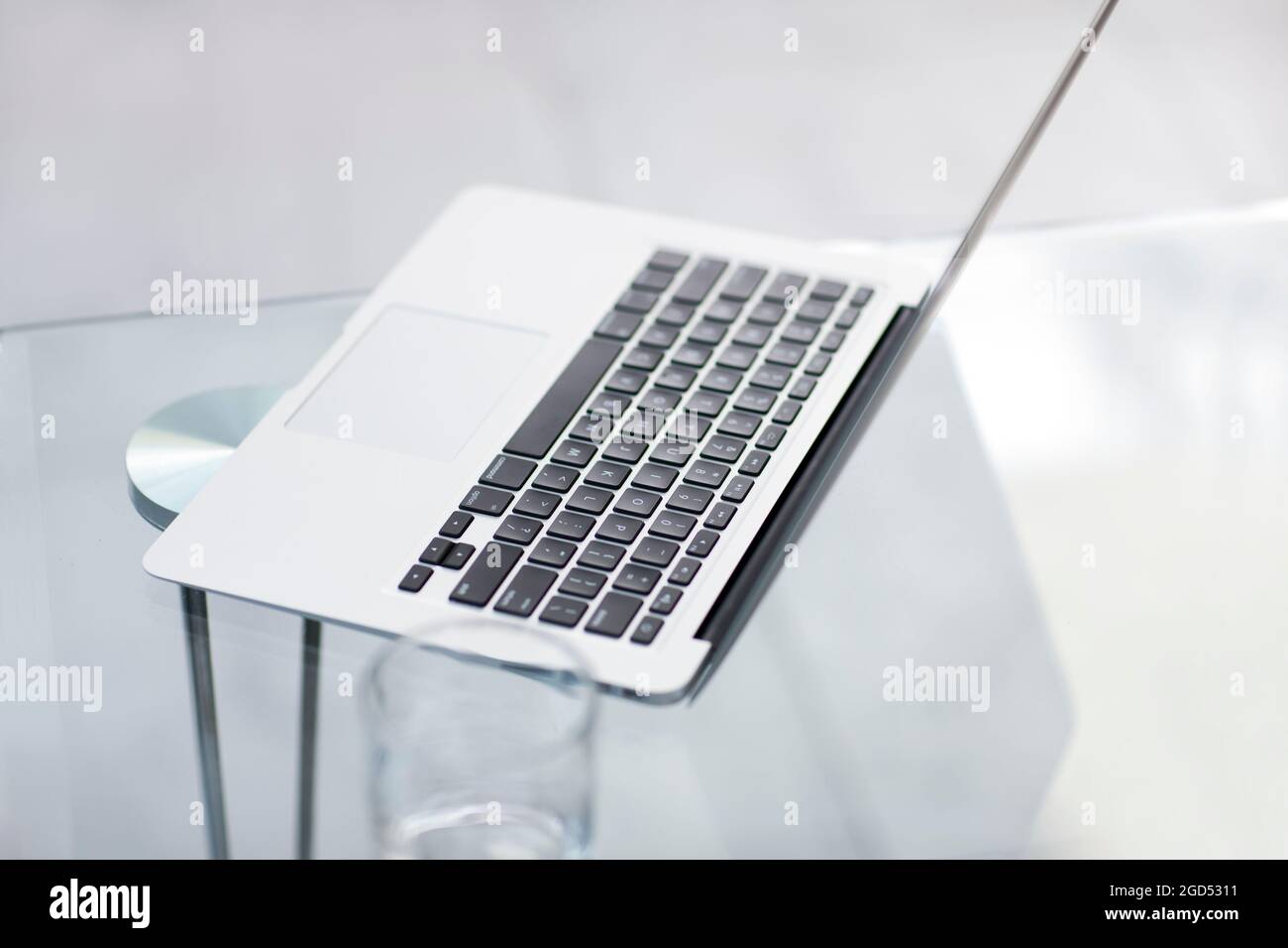 Laptop on glass desk Stock Photo - Alamy