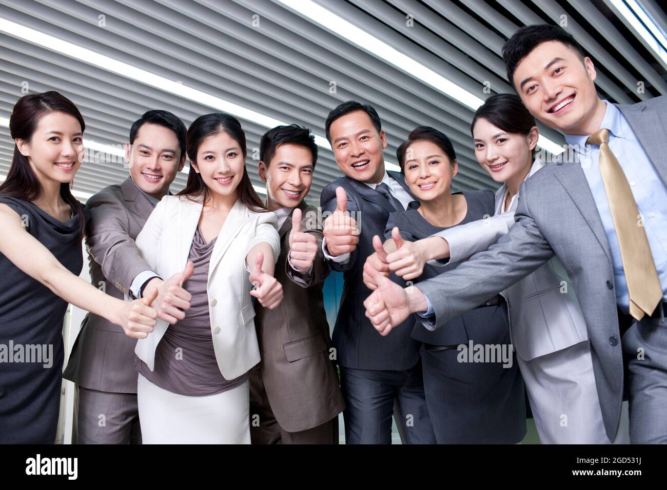 Cheerful businesspeople with thumbs up Stock Photo - Alamy