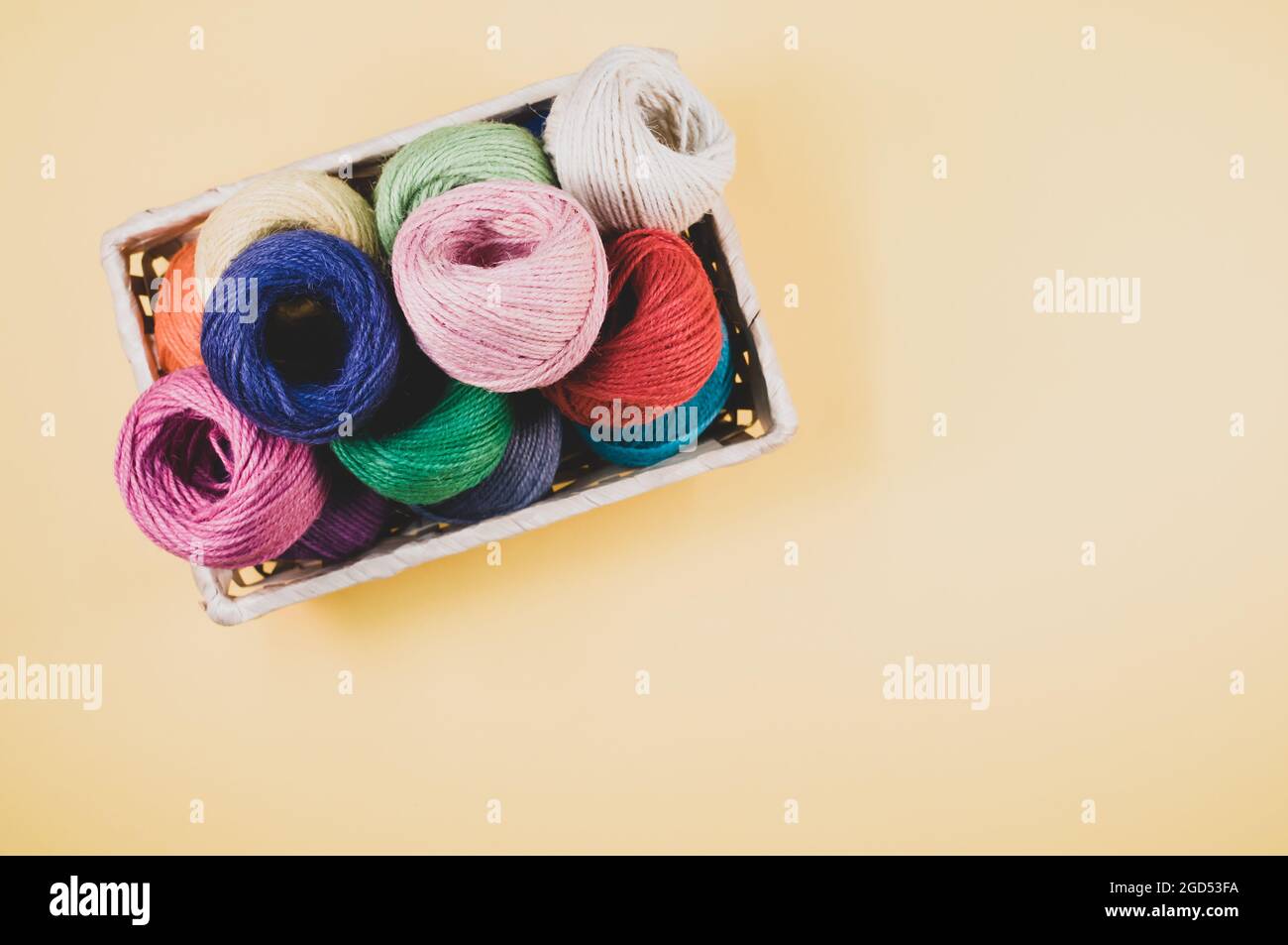 Top view of colorful yarn rolls isolated on a yellow background with ...