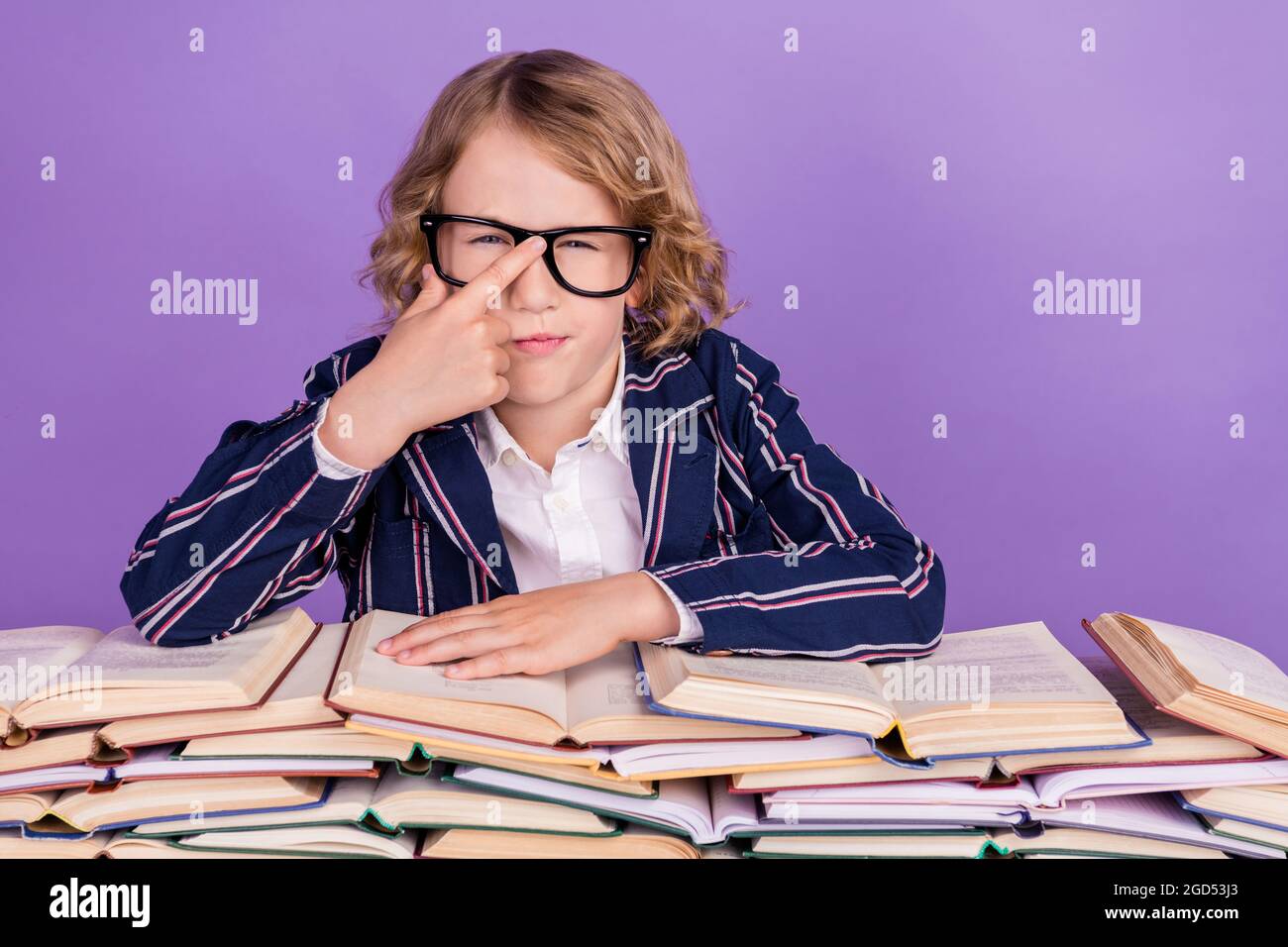 Portrait of attractive funny focused boy reading pile book touching ...