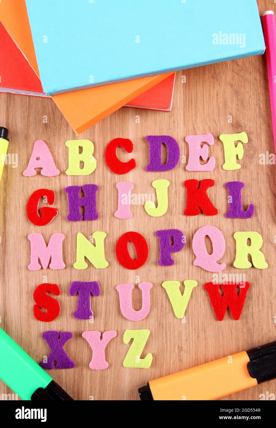 English alphabet, books and markers on wooden background Stock Photo ...