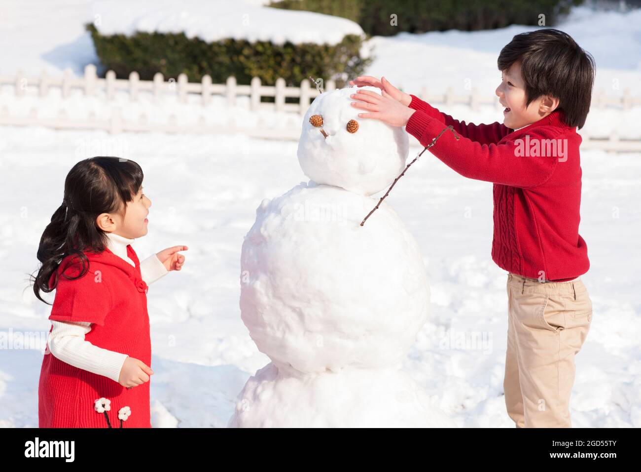 Two girls building snowman hi-res stock photography and images - Alamy