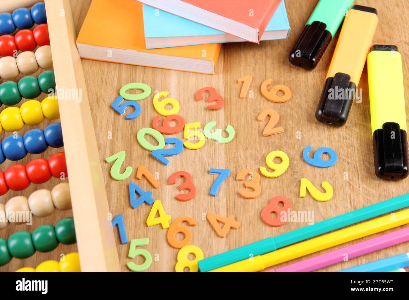 Colorful numbers, abacus, books and markers on wooden background Stock ...