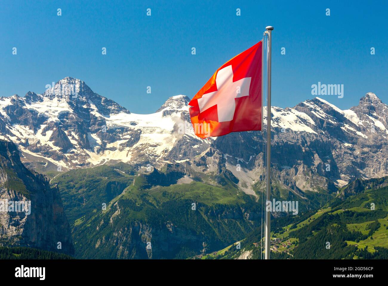 Swiss national flag on a background of snow-capped mountains ...