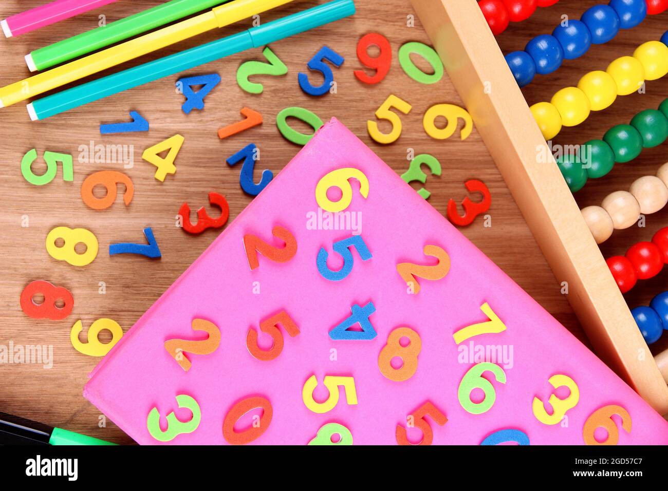 Colorful numbers, abacus, books and markers on wooden background Stock ...