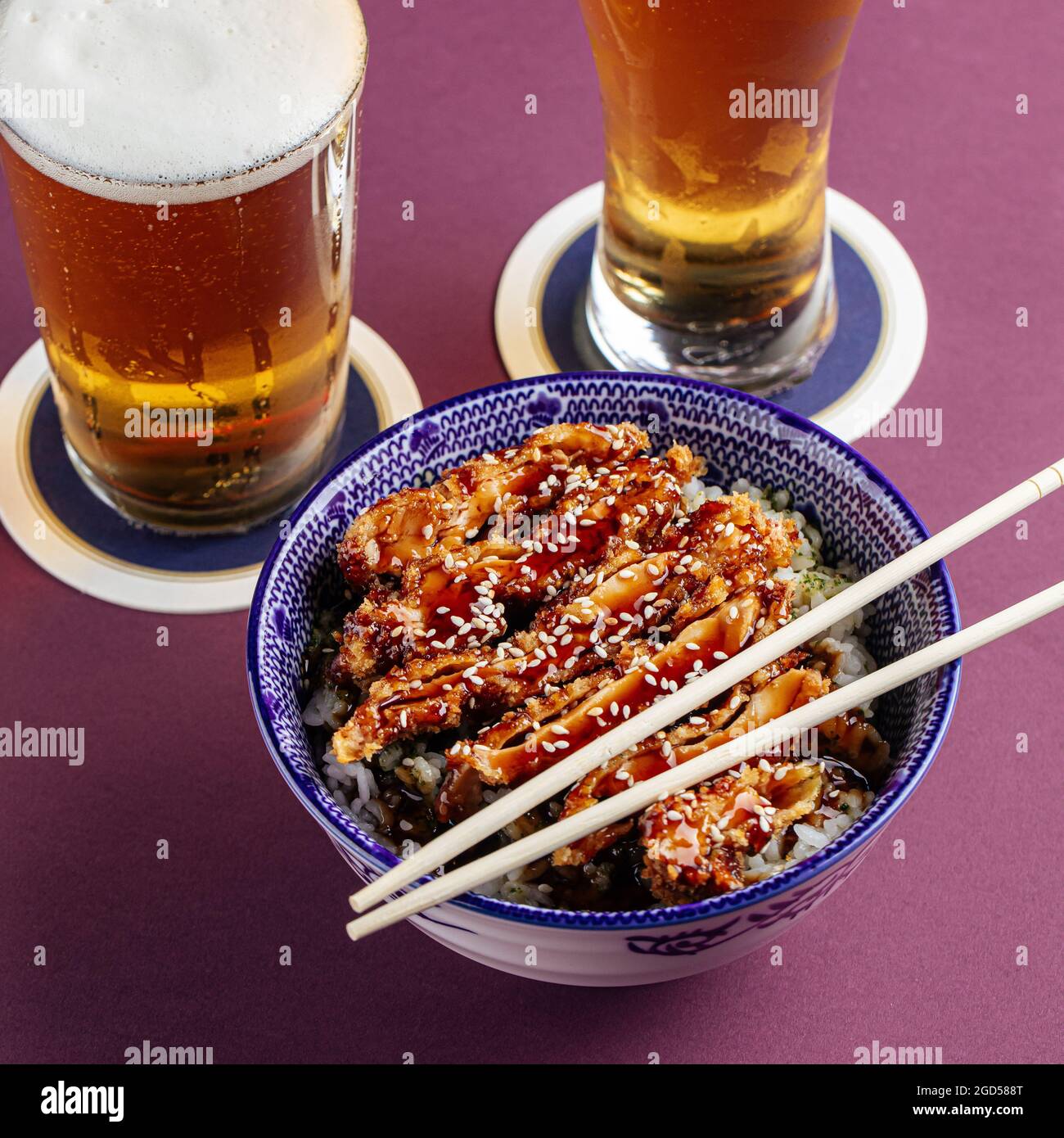 Katsudon chicken rice with beer on purple background Stock Photo - Alamy