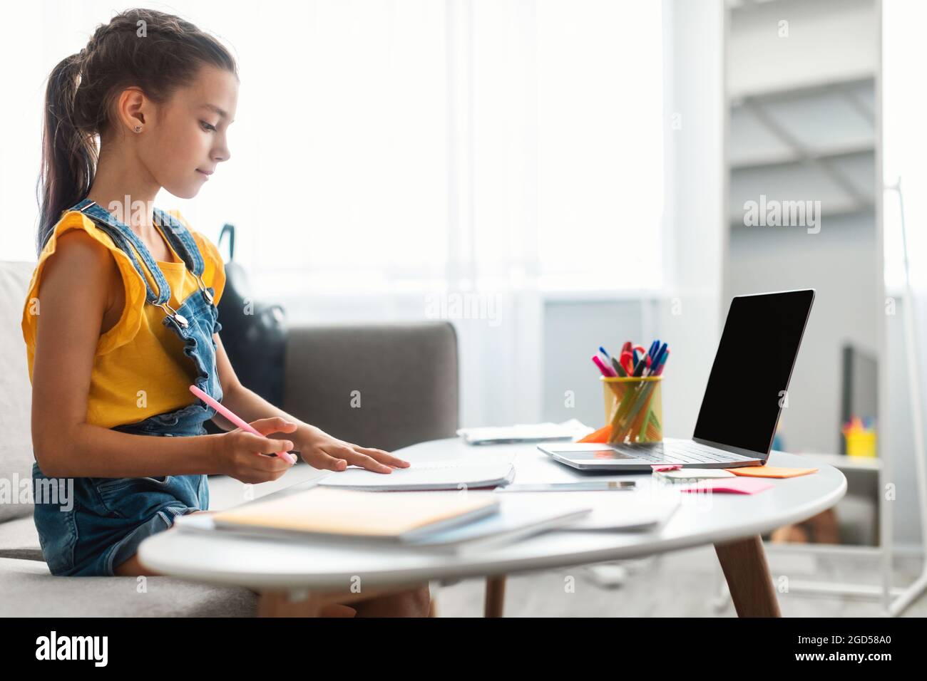 Online Education Concept. Profile side view of school girl studying at ...
