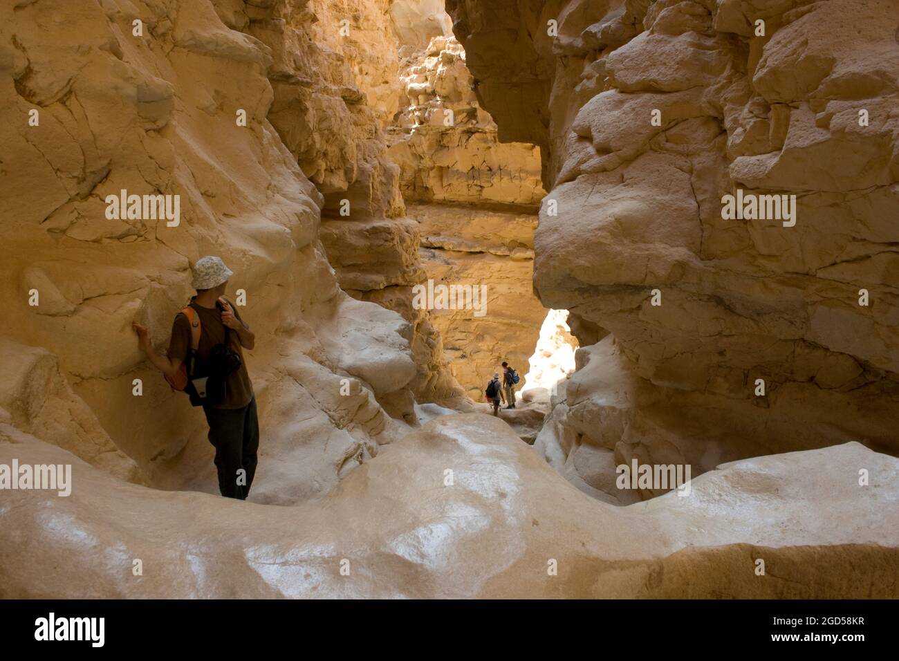 Hiker climbs the rope ladder in a water eroded cave at Barak Stream ...