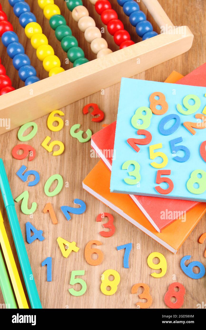 Colorful numbers, abacus, books and markers on wooden background Stock ...