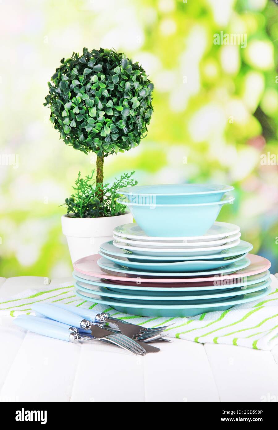 Clean dishes with flower on wooden table on natural background Stock ...