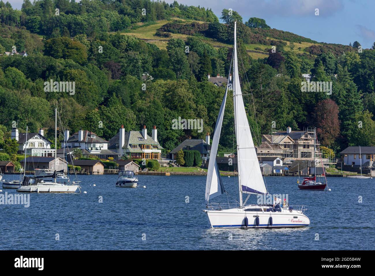 Yachting on lake Windermere in the lake district sailing past expensive ...