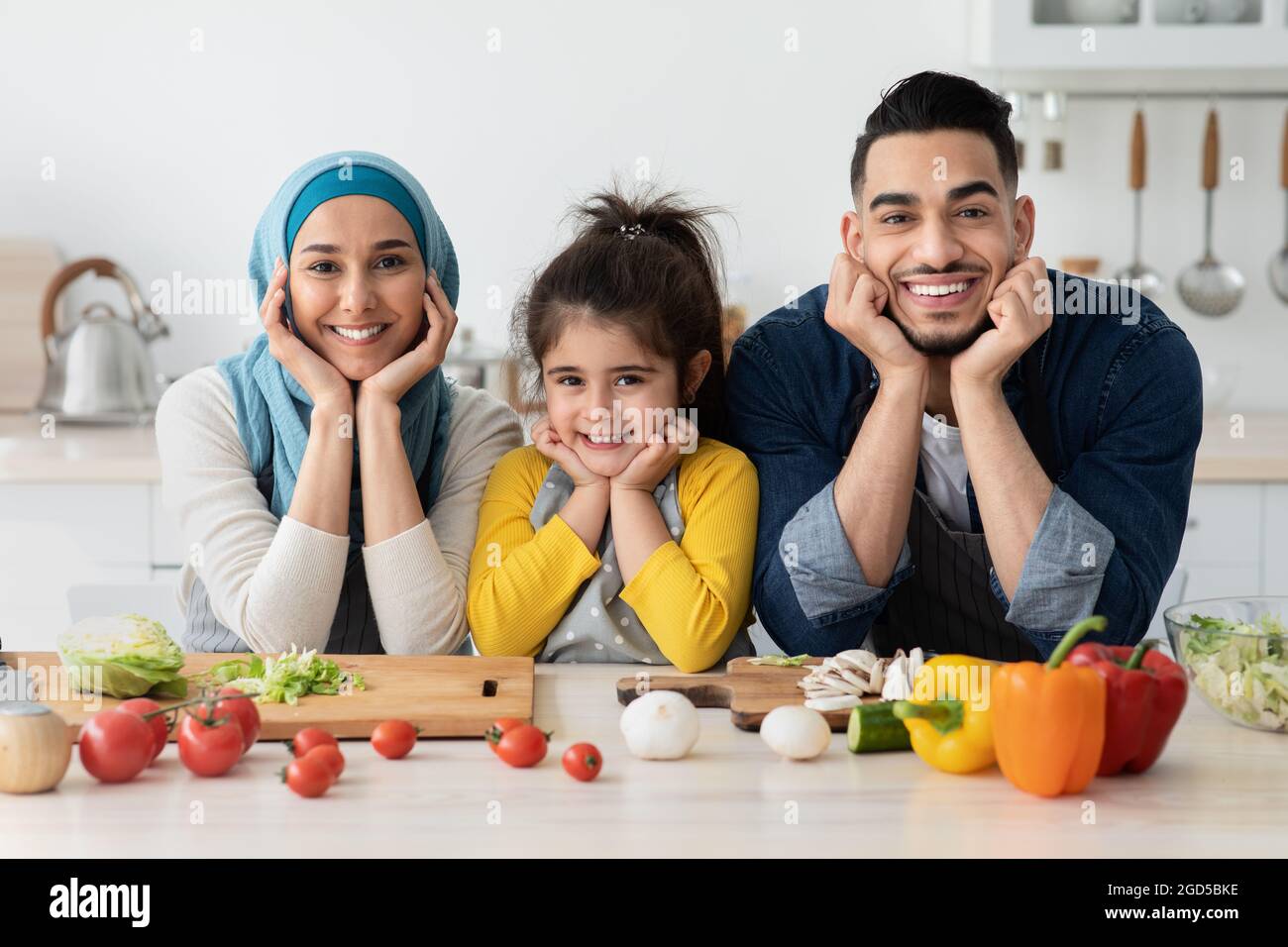 Portrait Of Happy Muslim Family Of Three Posing While Cooking In ...