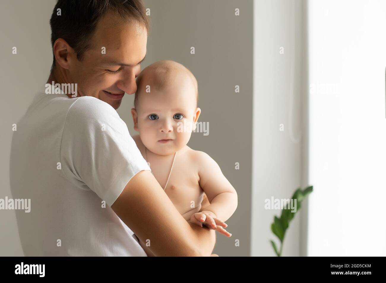 Father Hugging Newborn Baby in white bedroom Stock Photo - Alamy