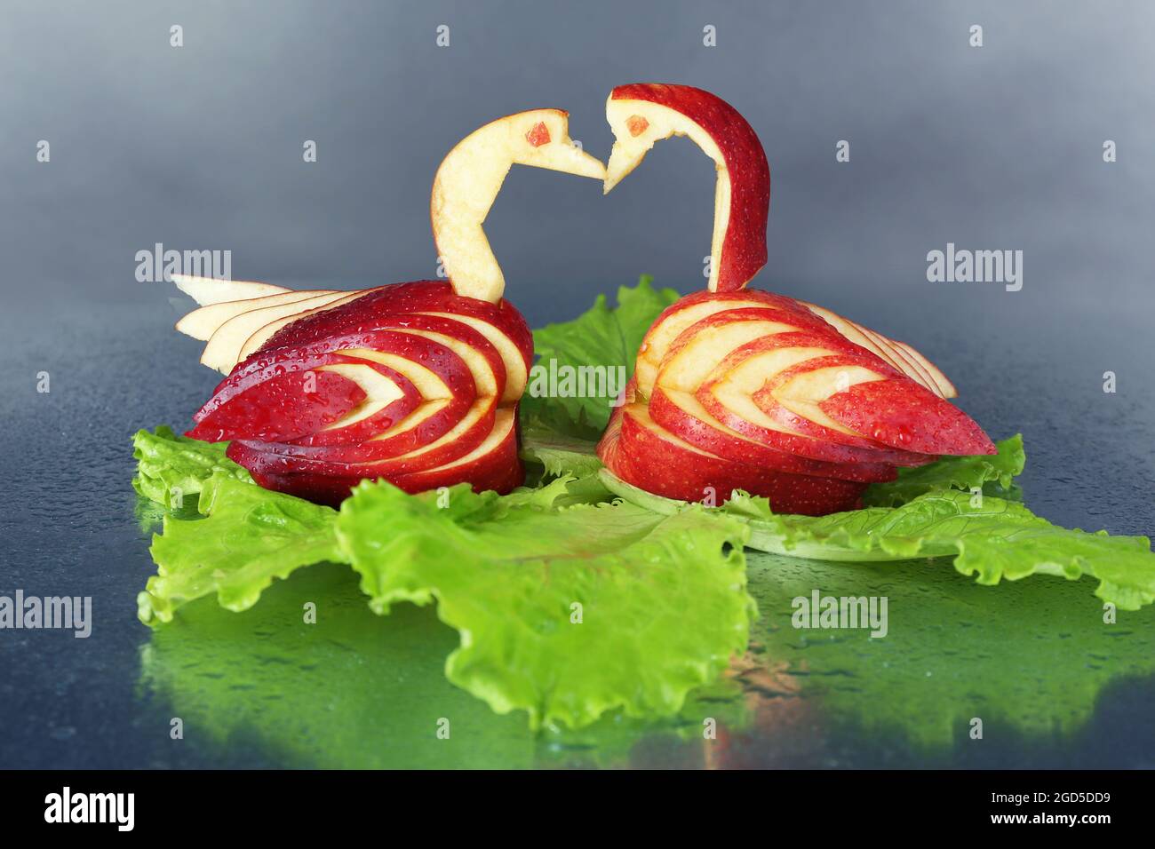 Carving fruit pattern of swan on grey wet background Stock Photo - Alamy