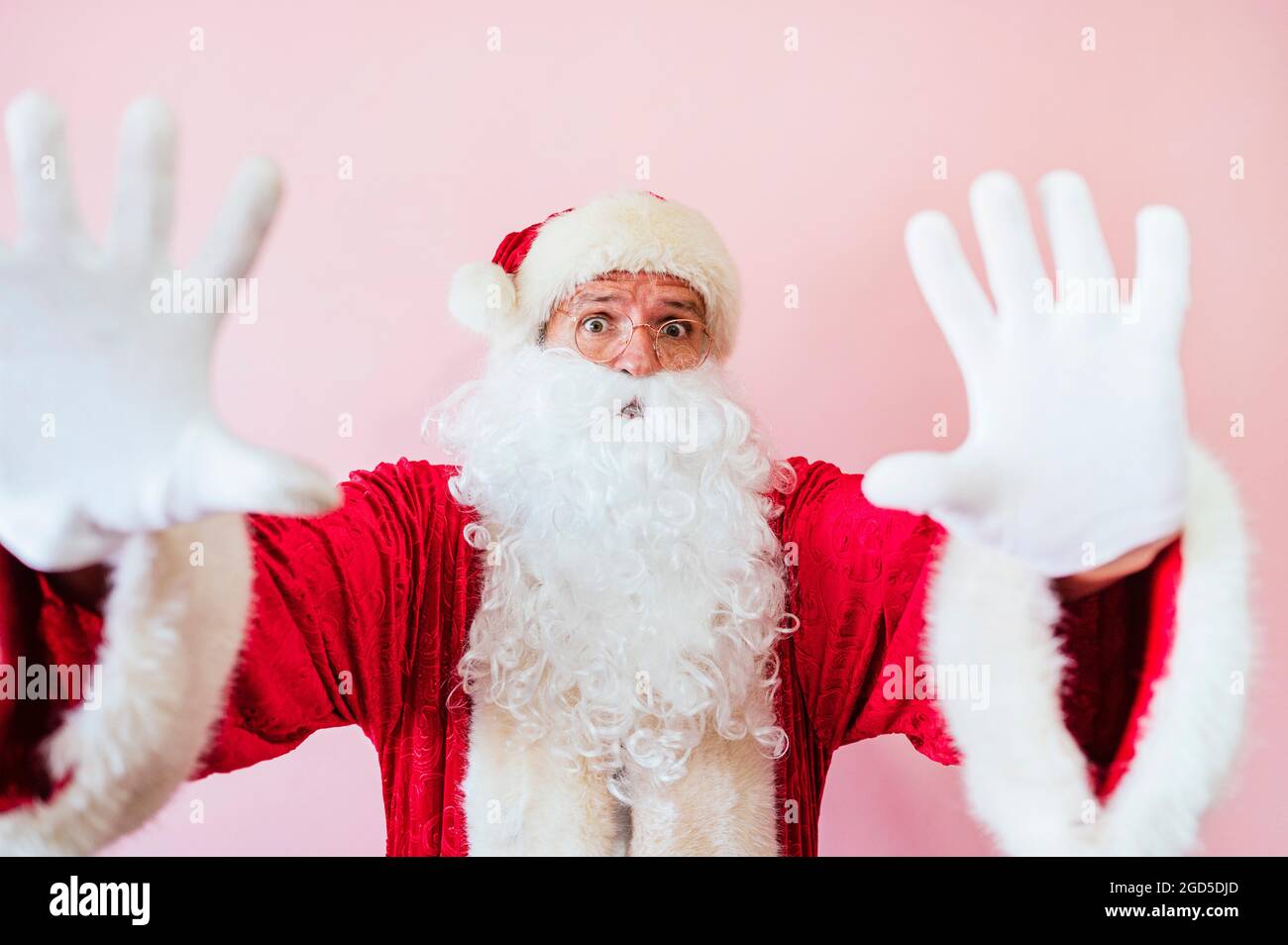 Man dressed as Santa Claus looking at camera with palms in stop sign ...