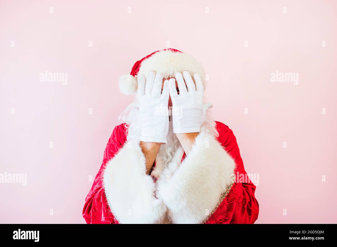 Man dressed as Santa Claus covering his face with his hands Stock Photo ...