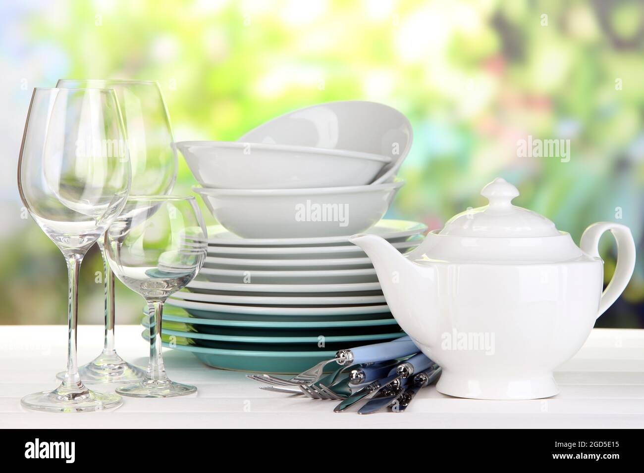 Clean dishes on table on natural background Stock Photo - Alamy