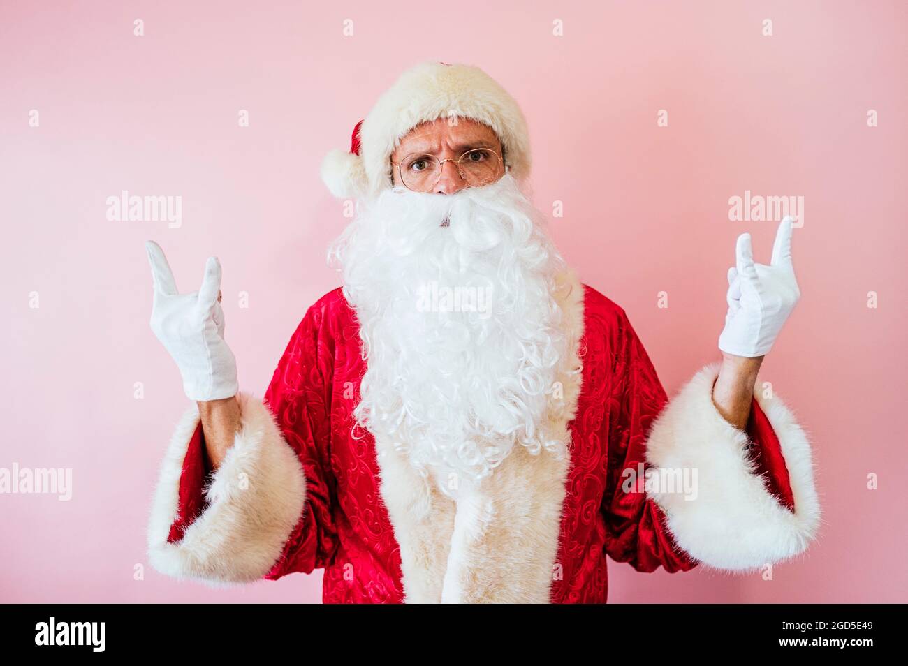 Man dressed as Santa Claus making horns gesture with his hands Stock ...