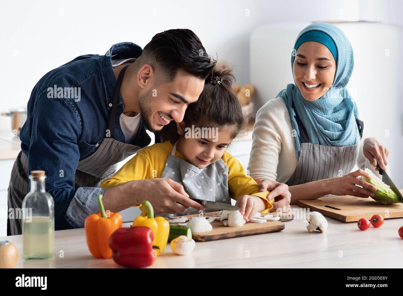 Young Arab Father Showing How To Chop Mushrooms To His Little Daughter ...
