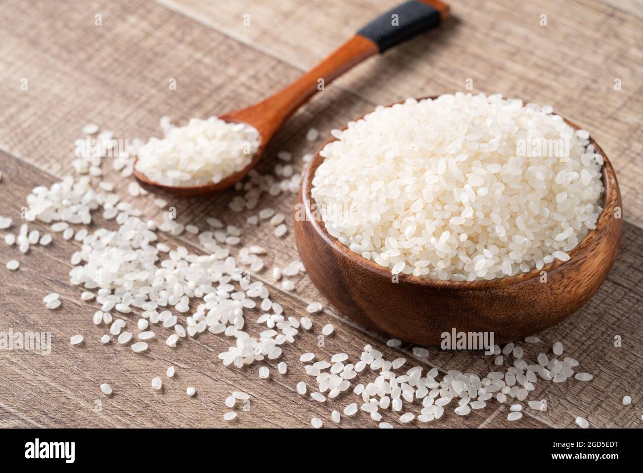 Raw white polished milled edible rice on wooden table background in a ...