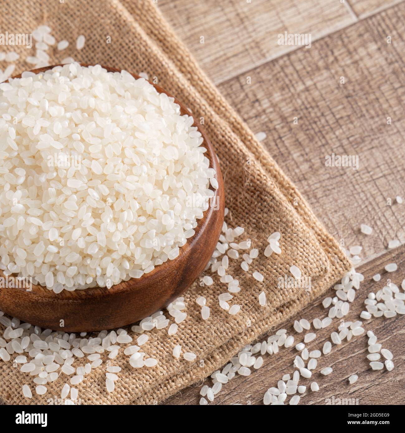 Raw white polished milled edible rice on wooden table background in a ...