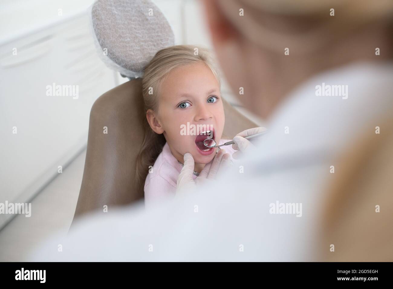 Pediadontist examining teeth of her cute small patient Stock Photo - Alamy
