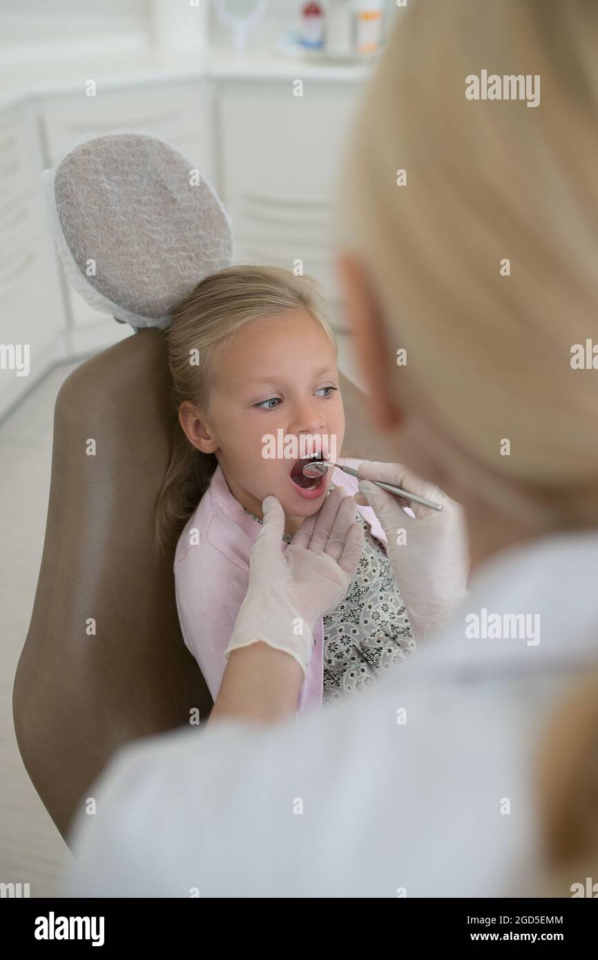 Pediadontist examining teeth of her cute small patient Stock Photo - Alamy