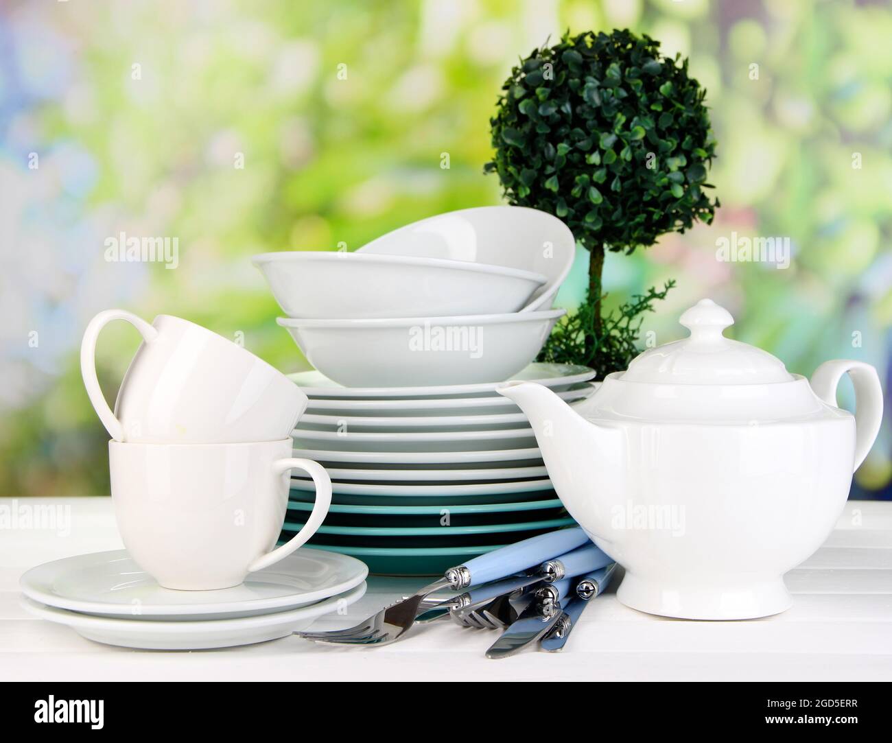 Clean dishes on table on natural background Stock Photo - Alamy