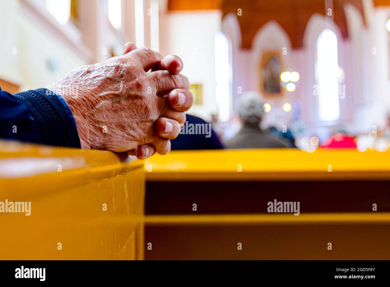Prayer's hands as they are praying with their priest at Sunday morning ...