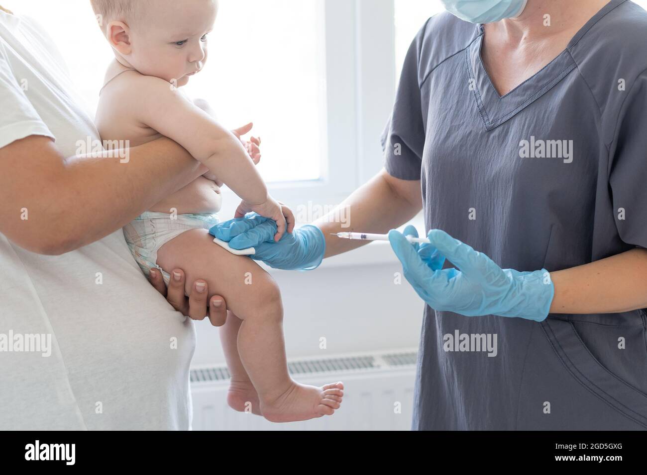 Pediatrician doctor with syringe, tense mother and baby Stock Photo - Alamy