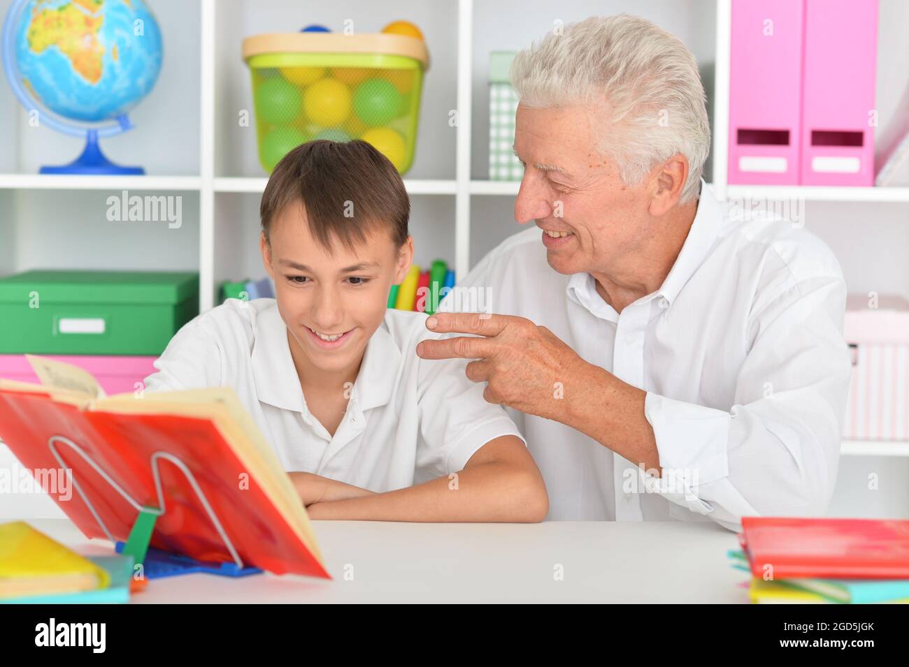 Grandfather with grandson doing homework at home Stock Photo - Alamy