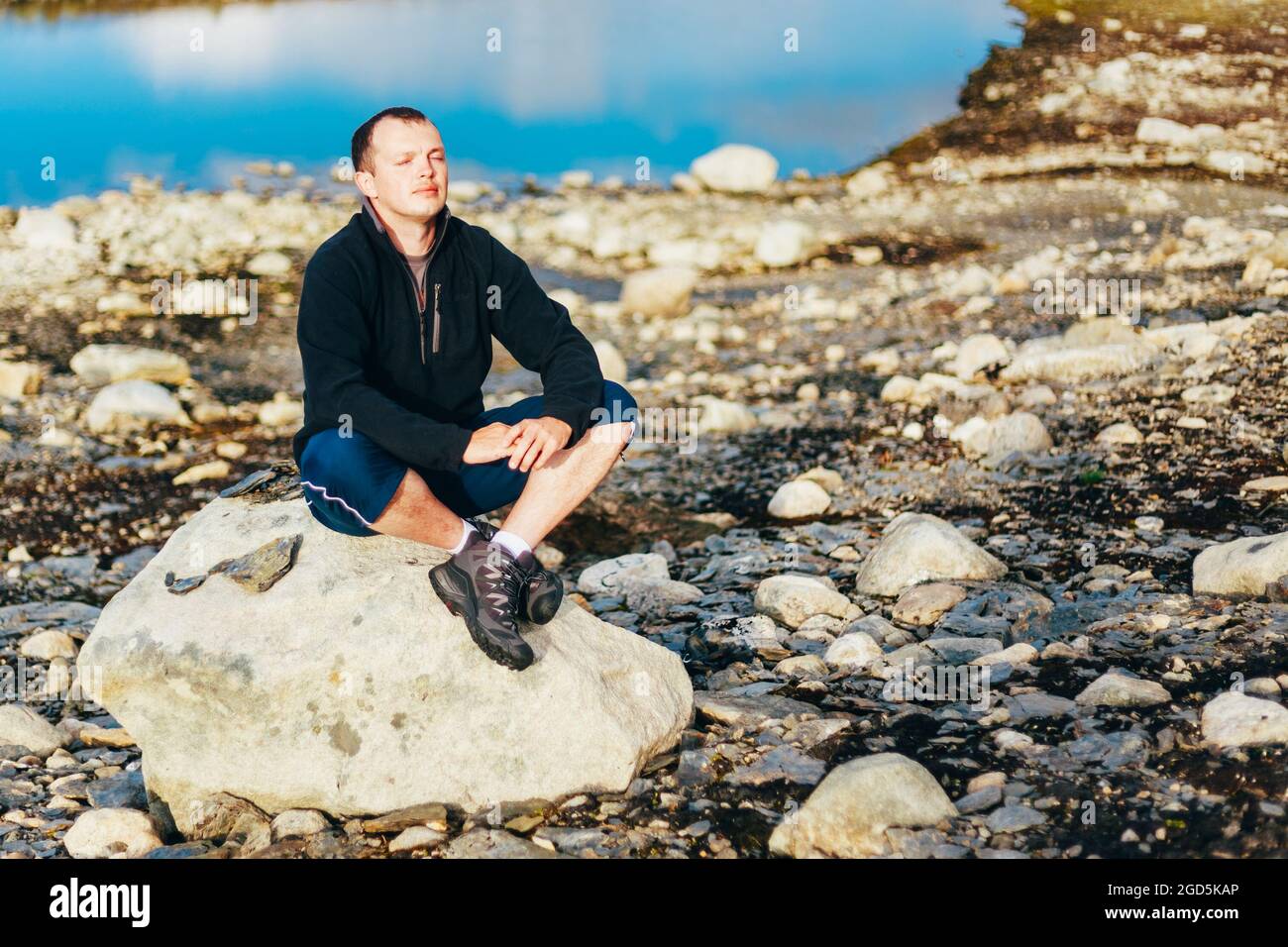 Man Sitting On Stone In Norwegian Mountains Stock Photo - Alamy